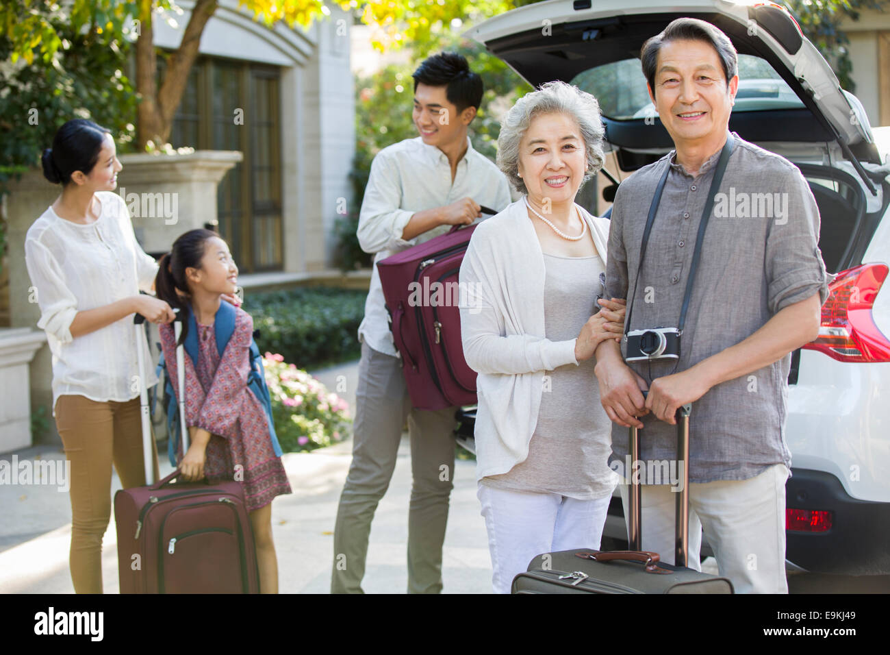Happy family packing for car trip Stock Photo - Alamy