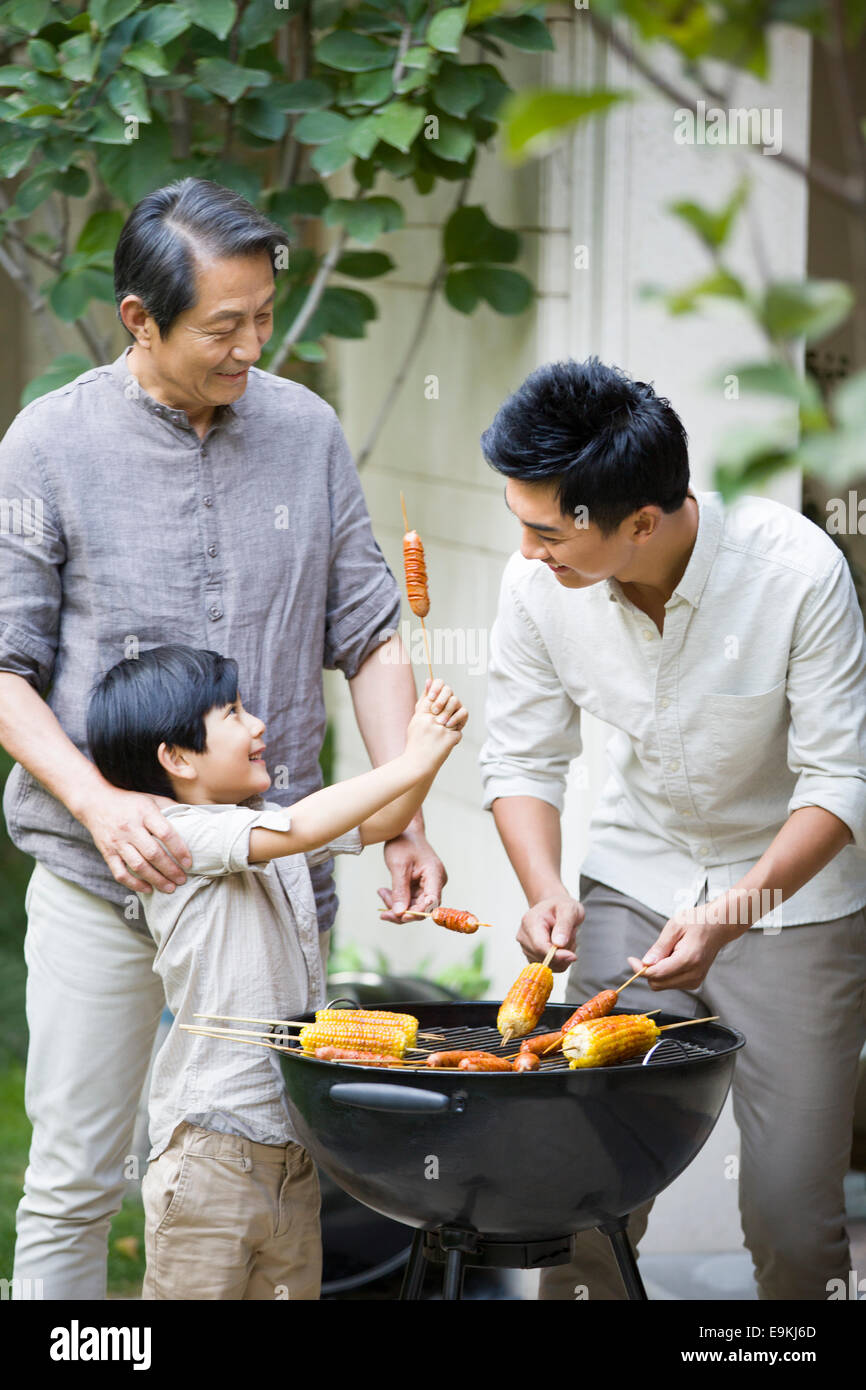 Happy family barbecuing Stock Photo - Alamy