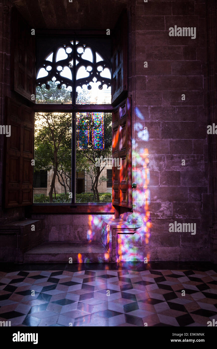 Dappled and coloured light from a stained glass window on another ...