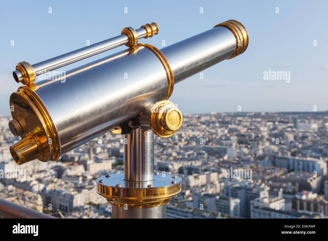 Shining metal telescope mounted on the railings of Eiffel Tower in ...