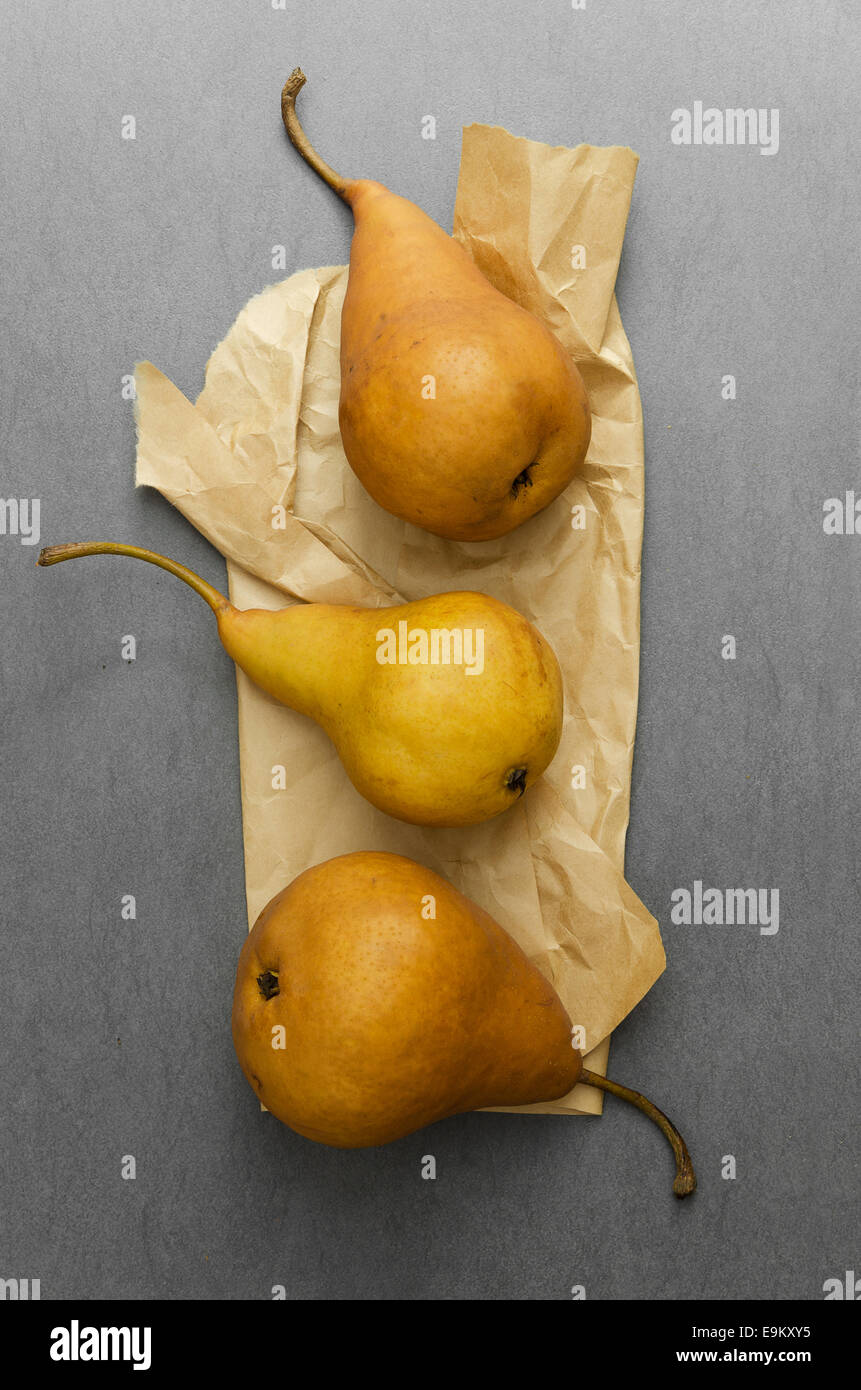 Three ripe pears over dark grey background Stock Photo - Alamy