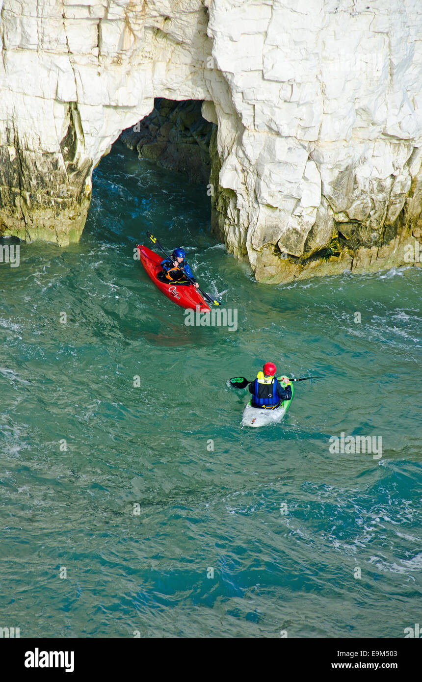 Sea kayaks passing through a rock arch at Old Harry Rocks, near Swanage ...