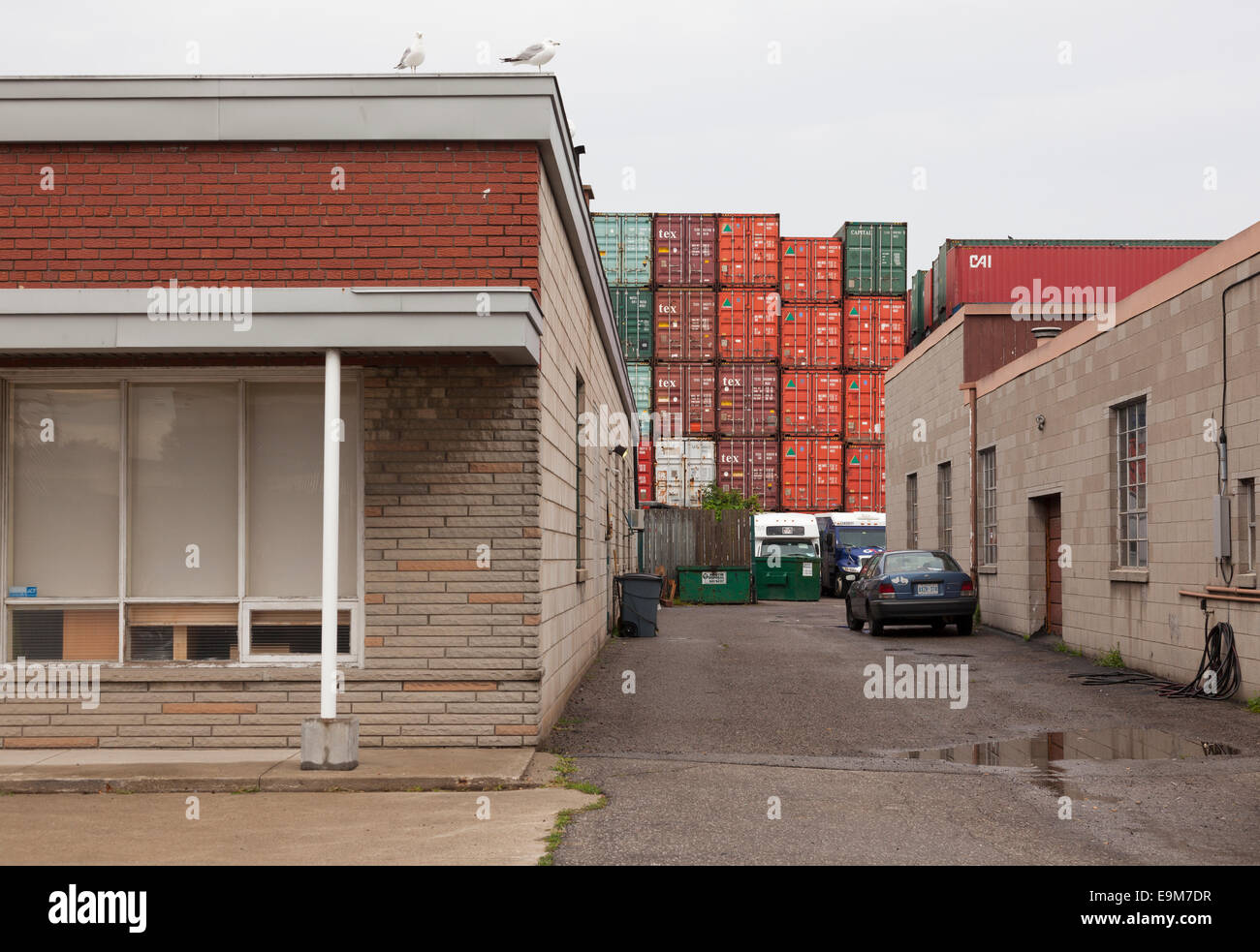 Looking down an industrial laneway with shipping containers in the ...