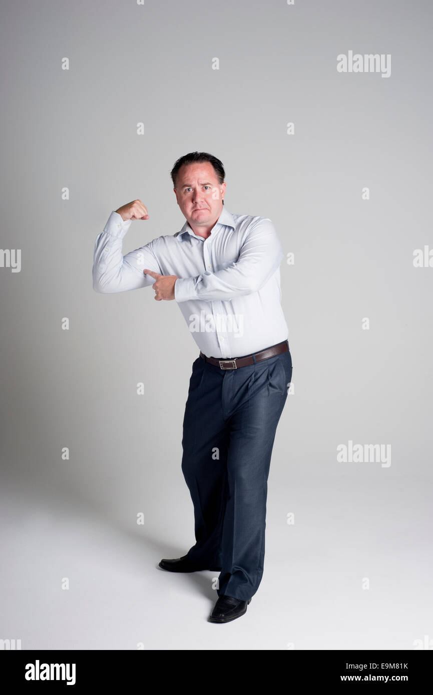 Man in business shirt flexing muscle and showing off bicep Stock Photo ...