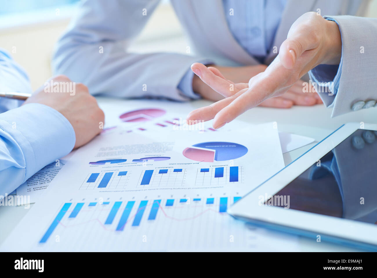 Close-up of female hand pointing at financial analysis while explaining ...