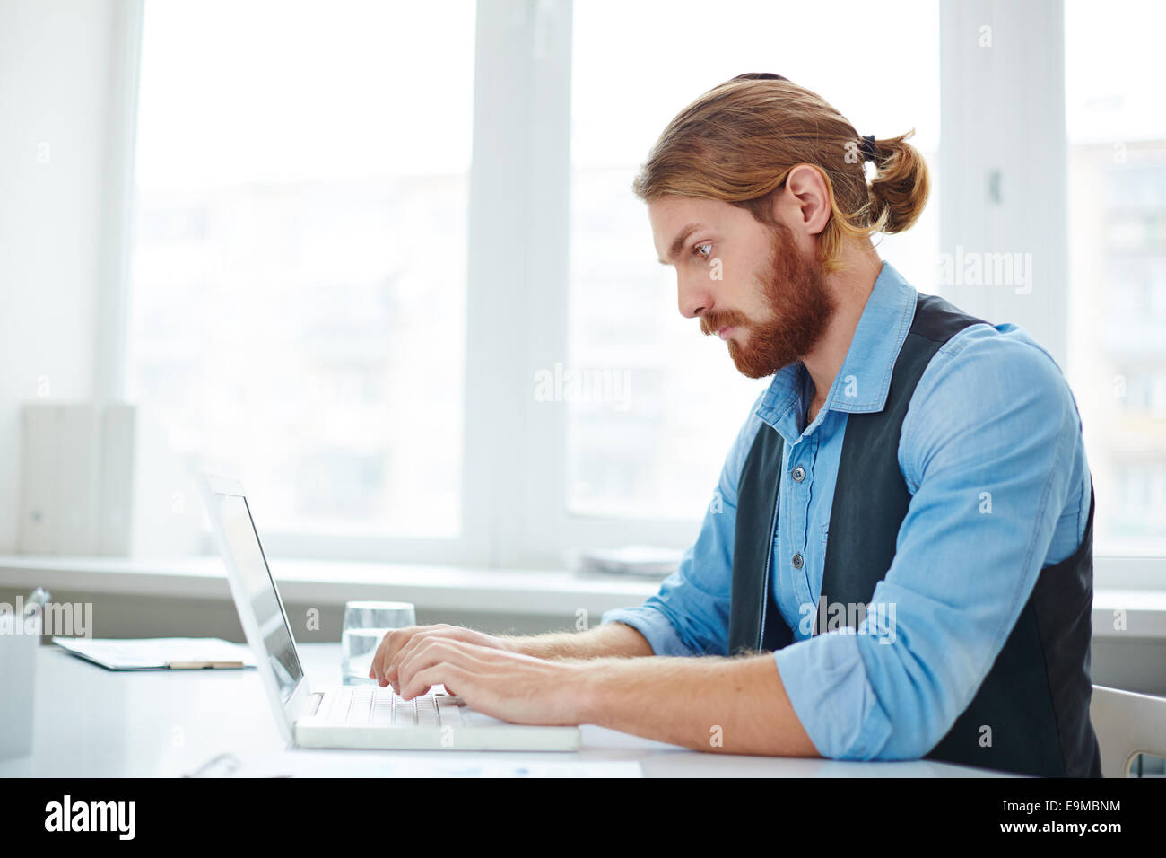 Serious businessman typing on laptop at workplace Stock Photo - Alamy