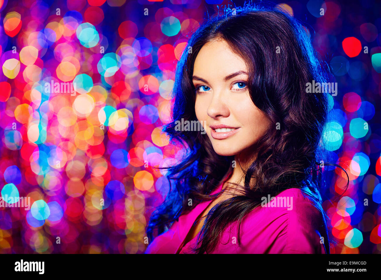 Charming woman looking at camera over sparkling background Stock Photo ...