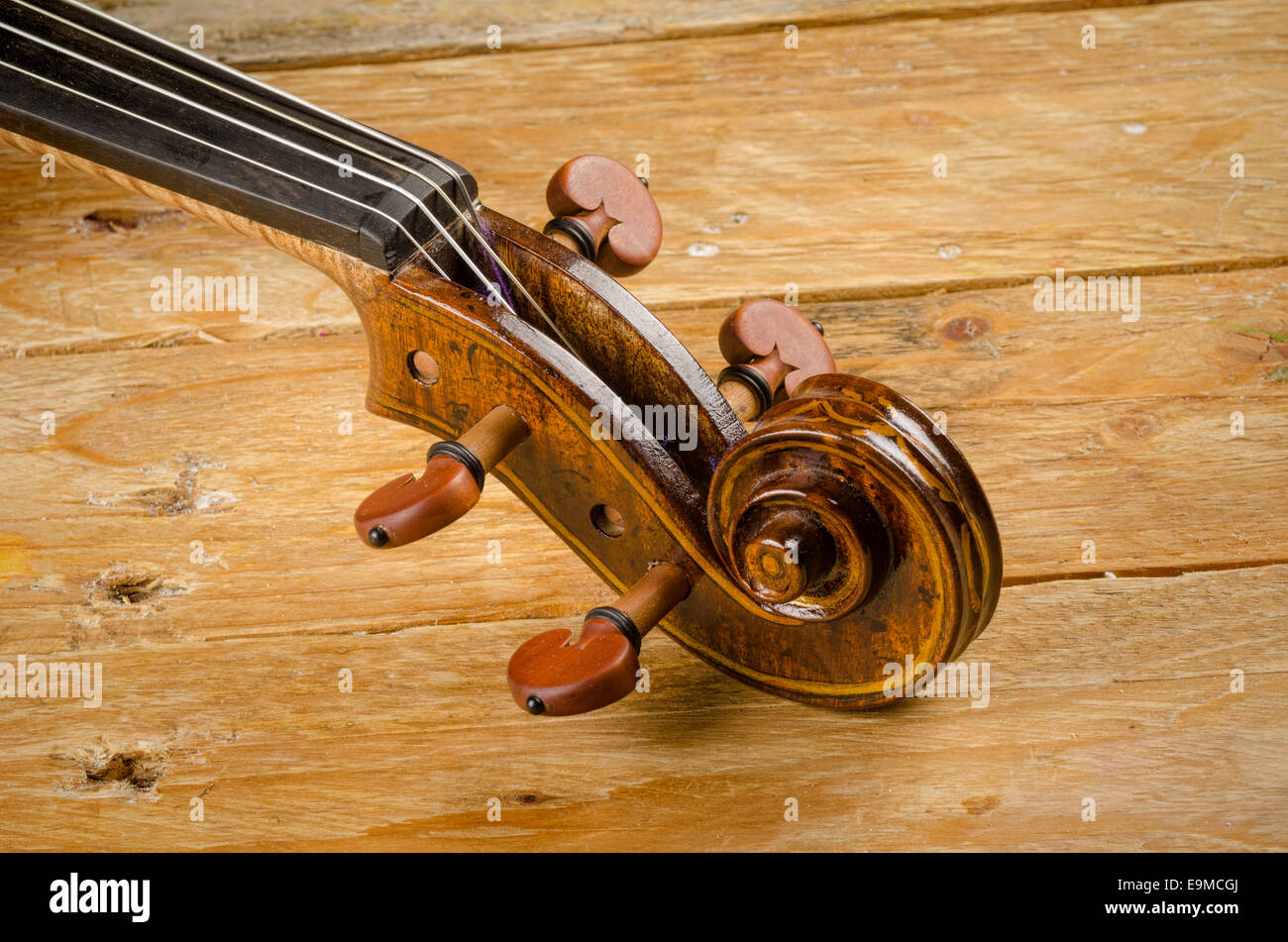 Violin neck displayed on a rustic wooden background Stock Photo - Alamy