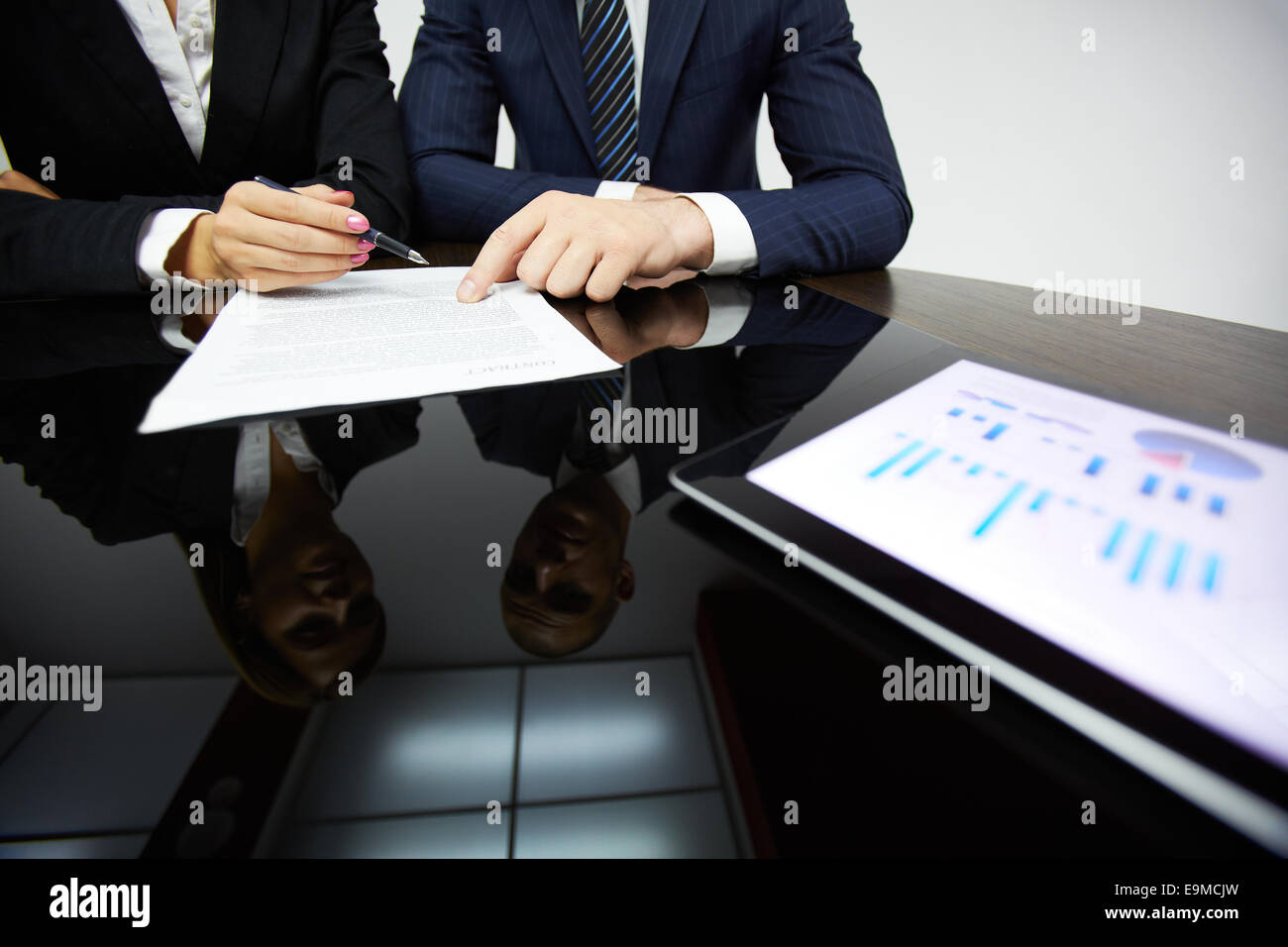 Business partners hands during reading contract Stock Photo - Alamy