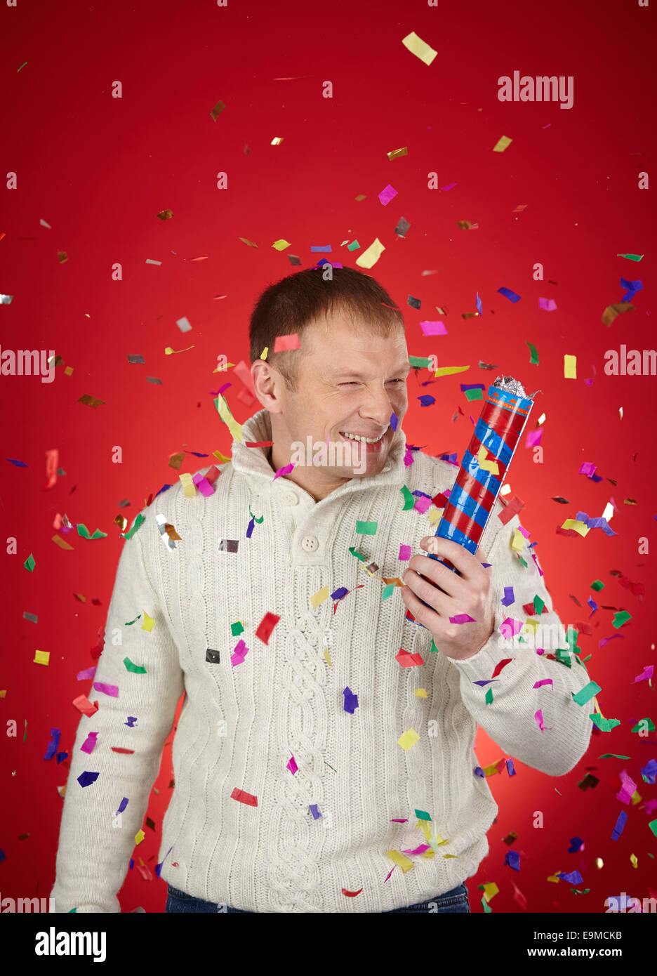 Joyful man having fun with confetti cracker Stock Photo - Alamy