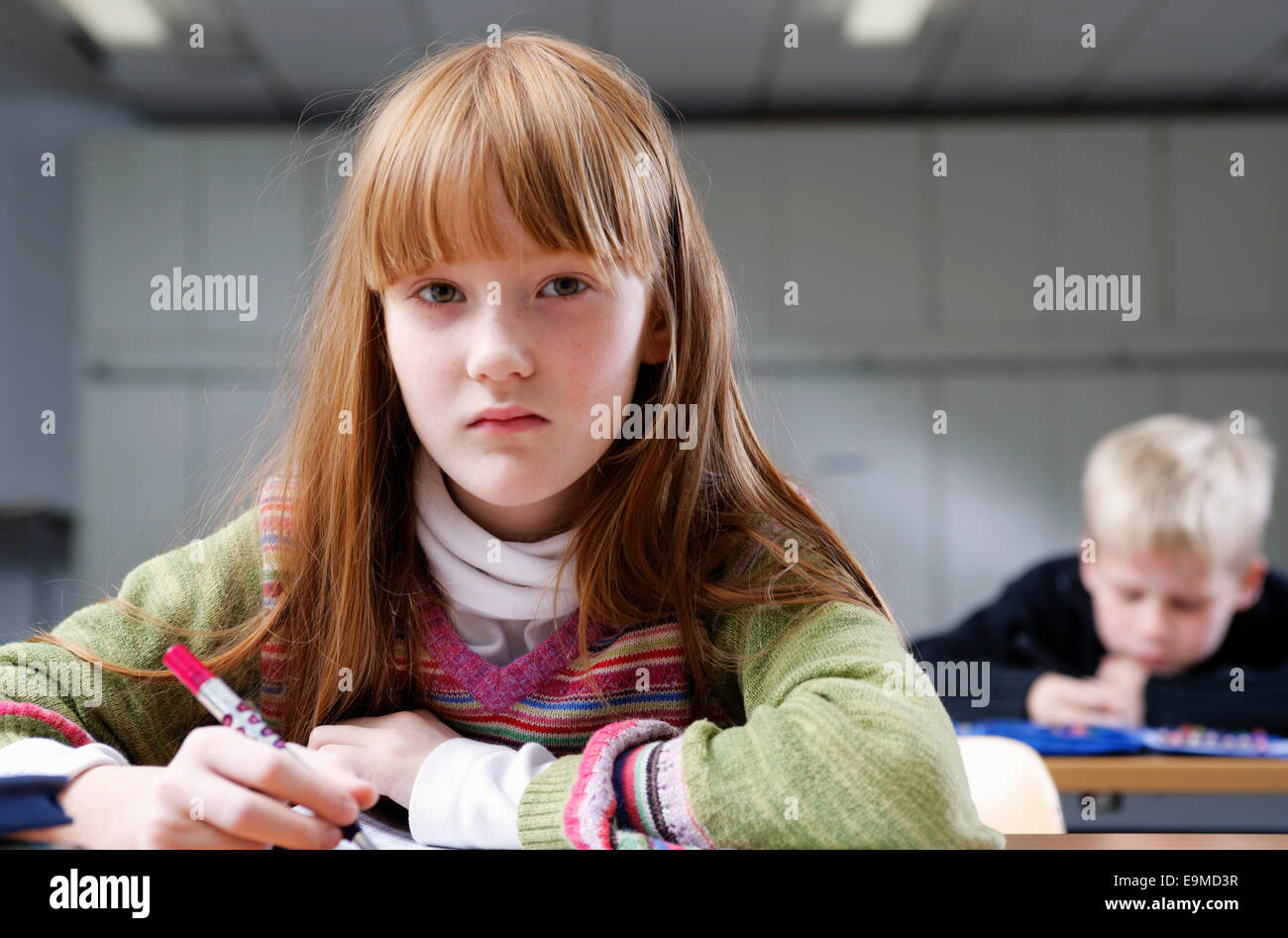 A girl holding a pen in her hand Stock Photo - Alamy