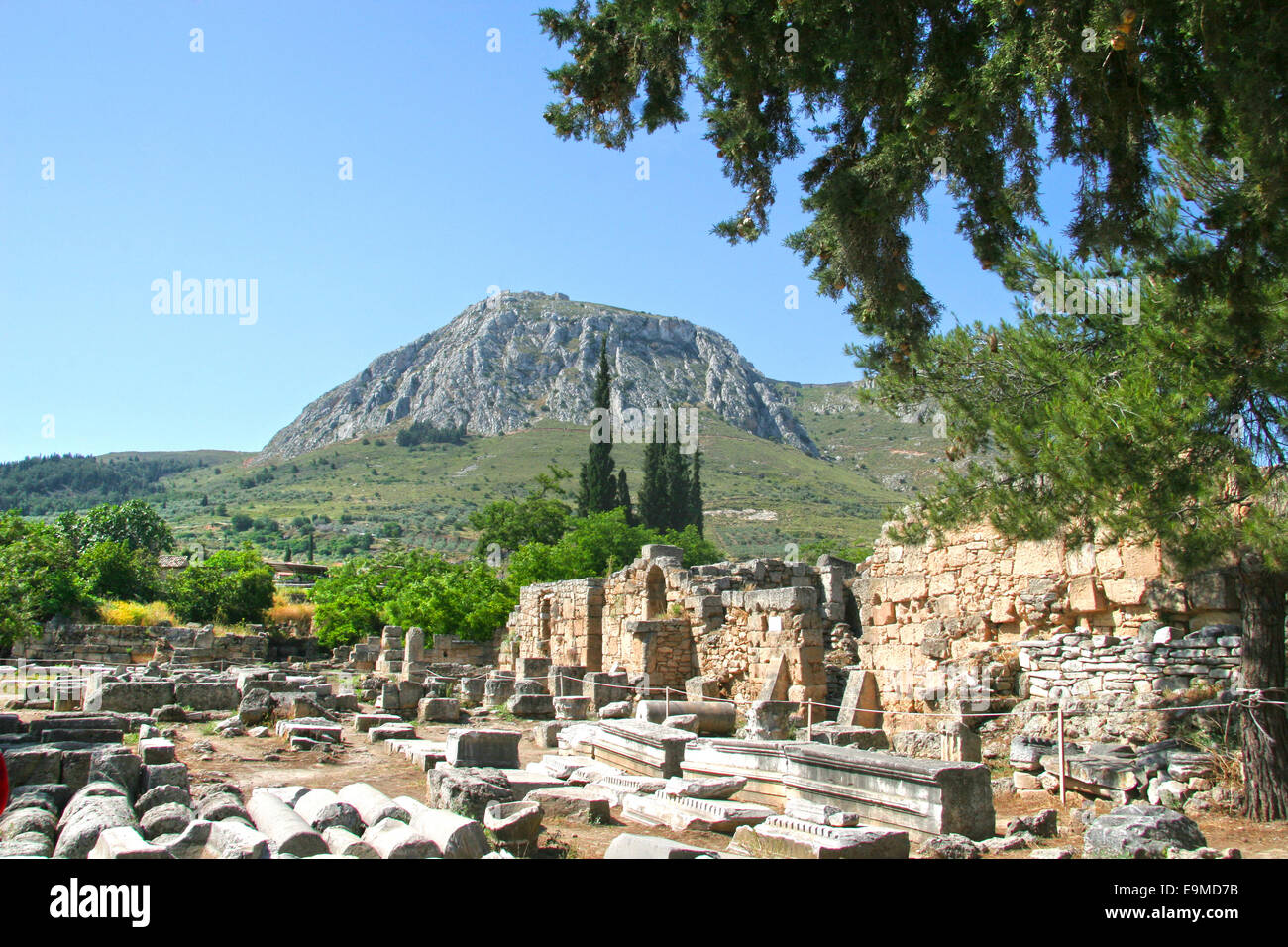Corinthian columns sit among the ruins at Corinth with a mountain in ...