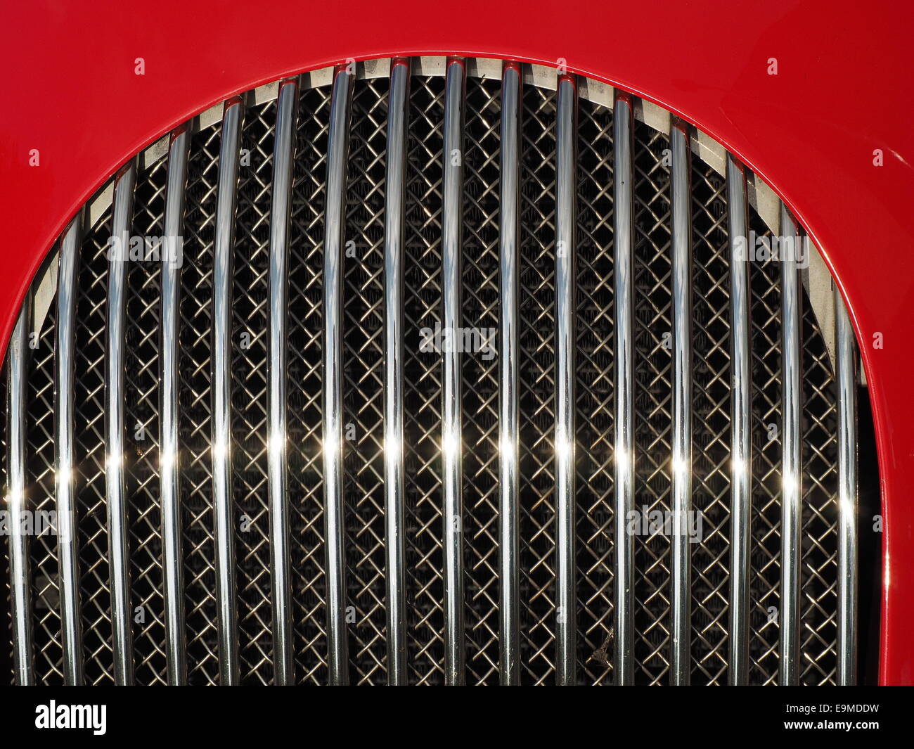 Gleaming radiator grille on bonnet of shiny red classic sportscar Stock ...