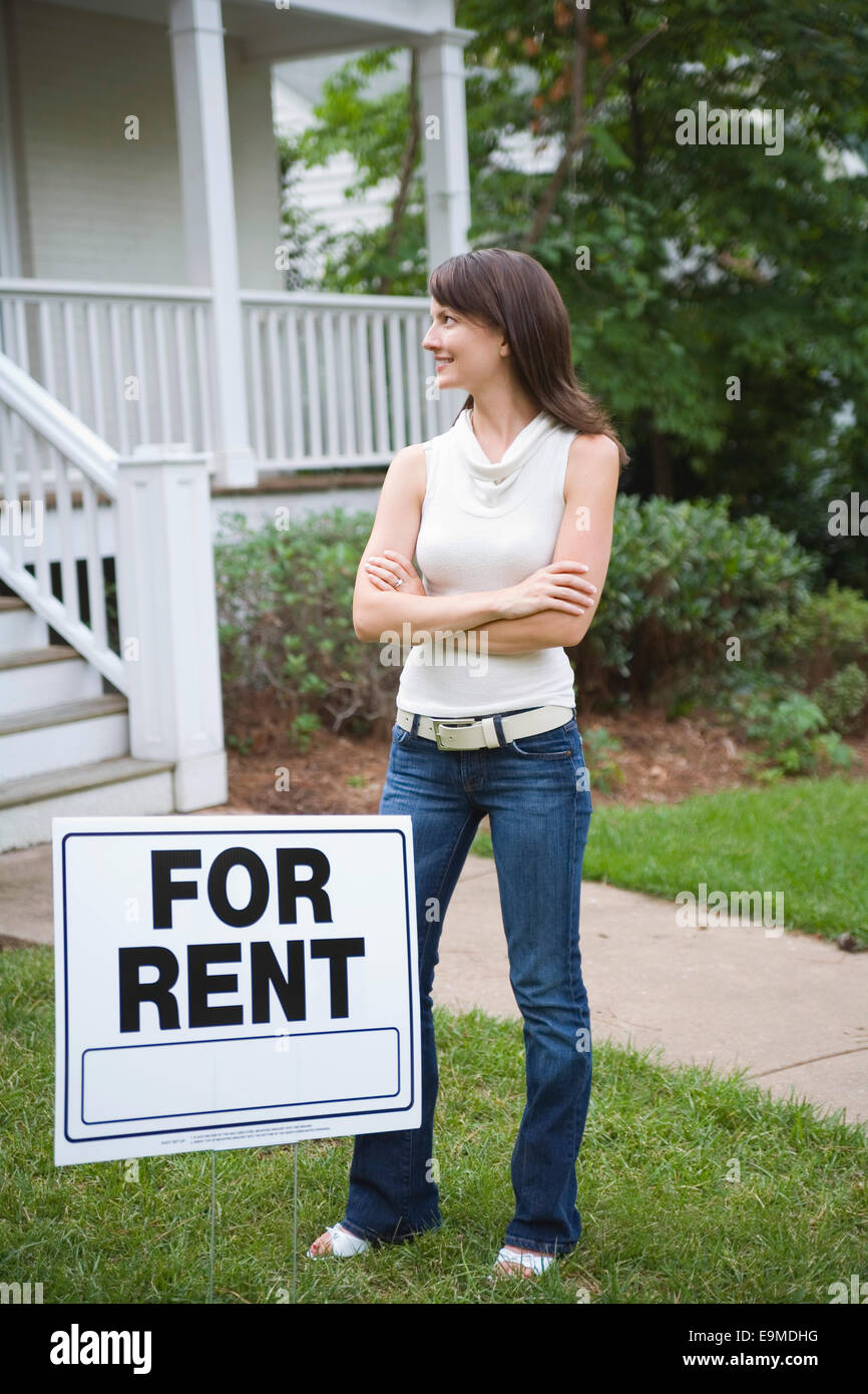 A young woman standing next to a ‘for rent’ sign Stock Photo - Alamy
