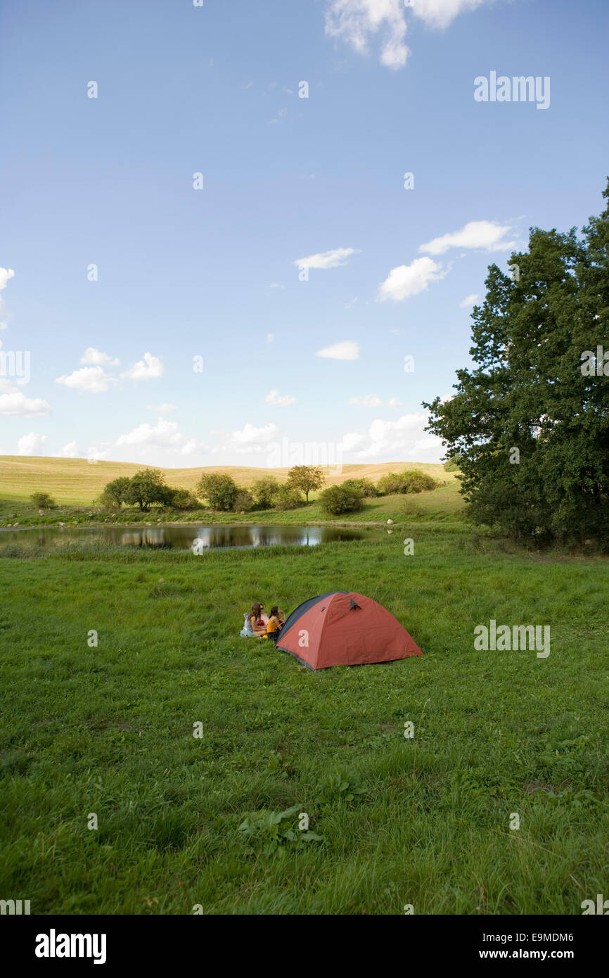 Distant view of people camping in field Stock Photo - Alamy