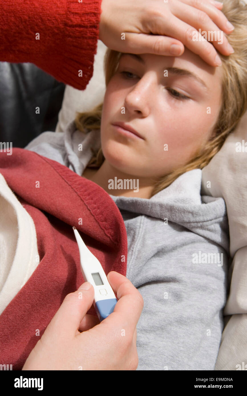 Teenage girl lying down with fever, digital thermometer Stock Photo - Alamy