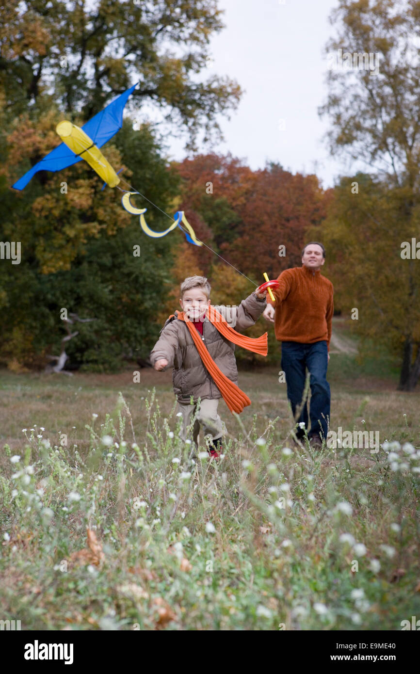 Father and son flying kite in autumn Stock Photo - Alamy