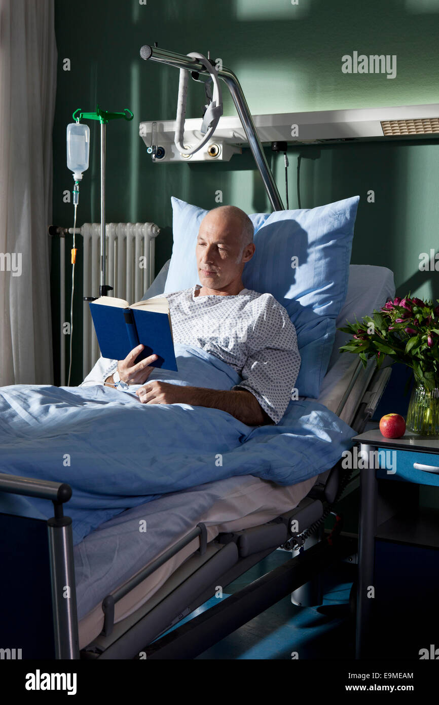 A man reading a book in a hospital bed Stock Photo - Alamy
