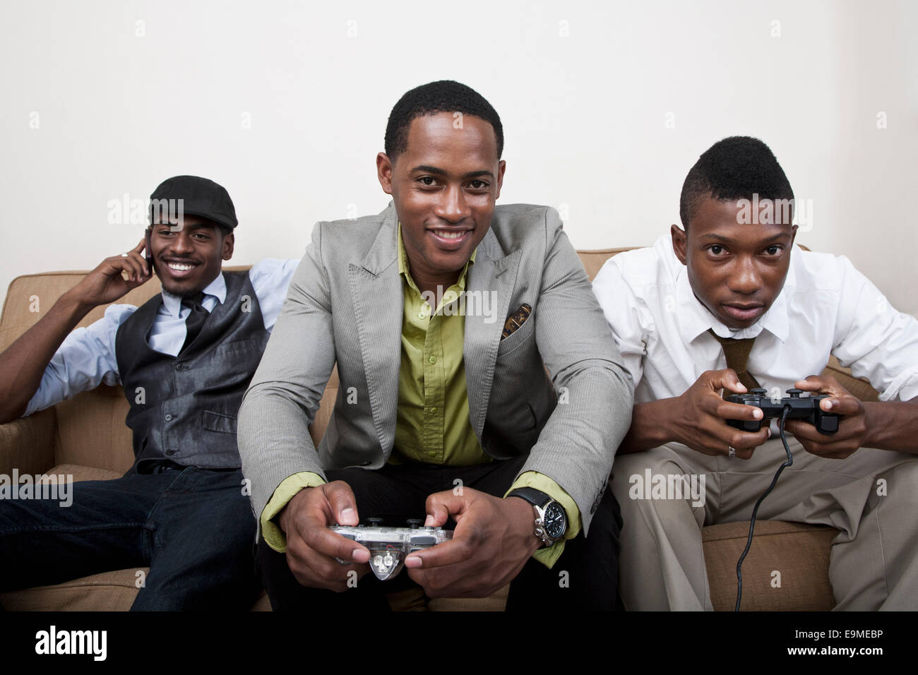 Three friends hanging out in a living room Stock Photo - Alamy