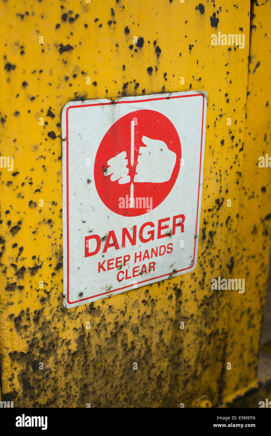 Warning sign on yellow wall outdoors Stock Photo - Alamy