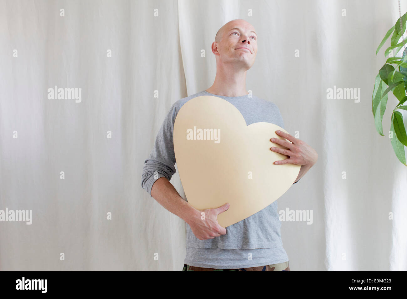 Mature man holding heart shape at home Stock Photo - Alamy