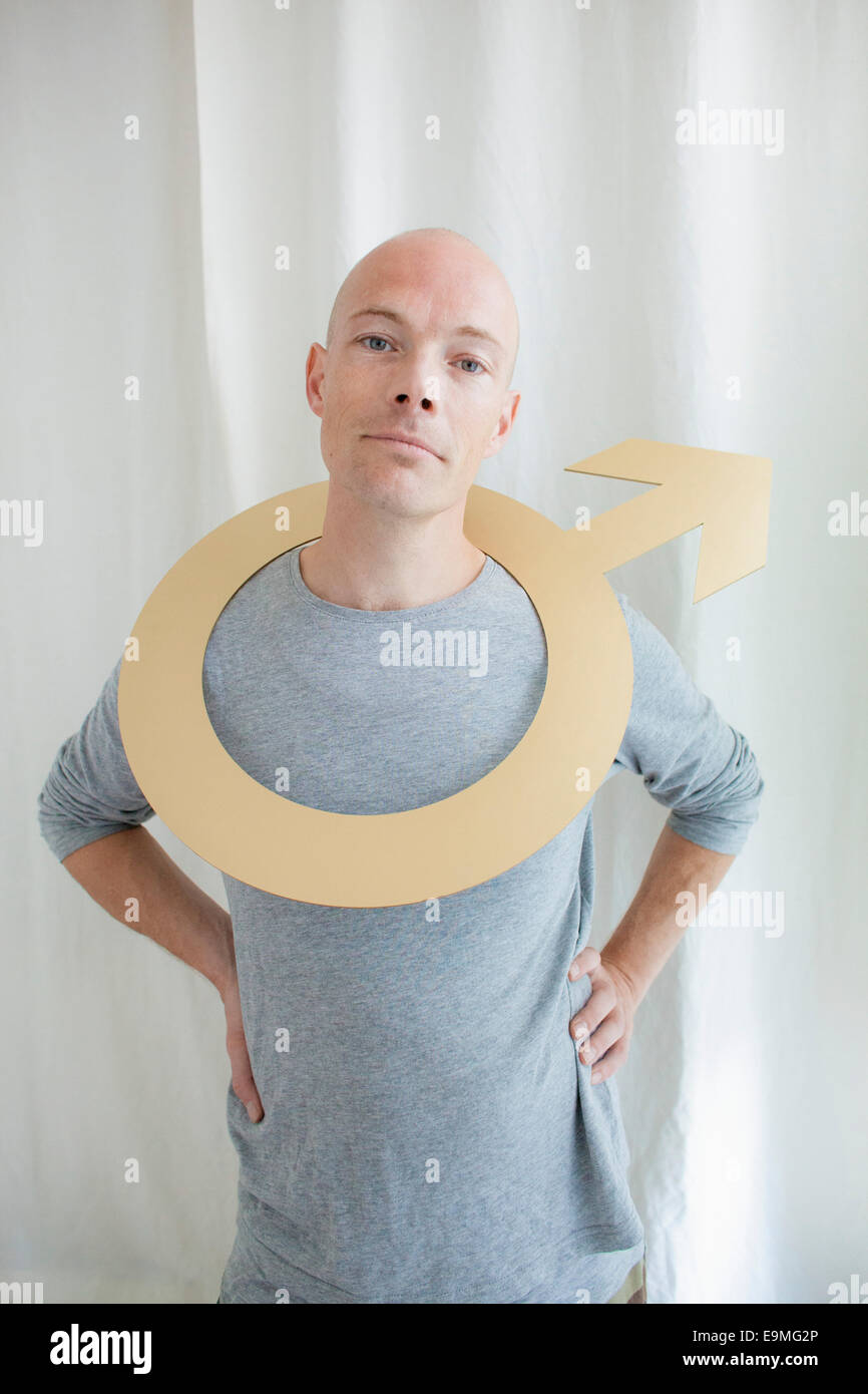 Portrait of man wearing male symbol in neck at home Stock Photo - Alamy