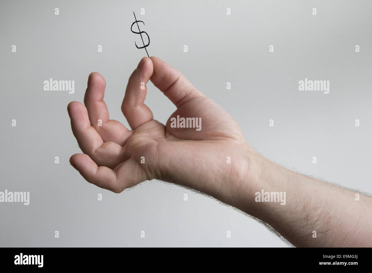Cropped image of man's hand holding dollar sign against gray background ...