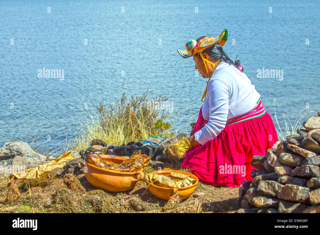 Peruvian woman in traditional clothing is cooking the pachamanca on ...