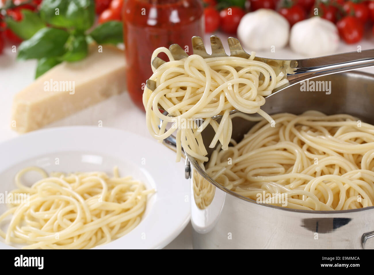 Cooking spaghetti pasta: serving noodles from pot on plate Stock Photo ...