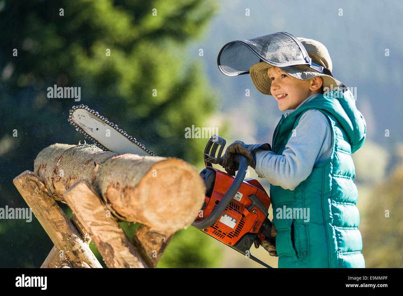 boy of eight with chainsaw cutting log Stock Photo - Alamy