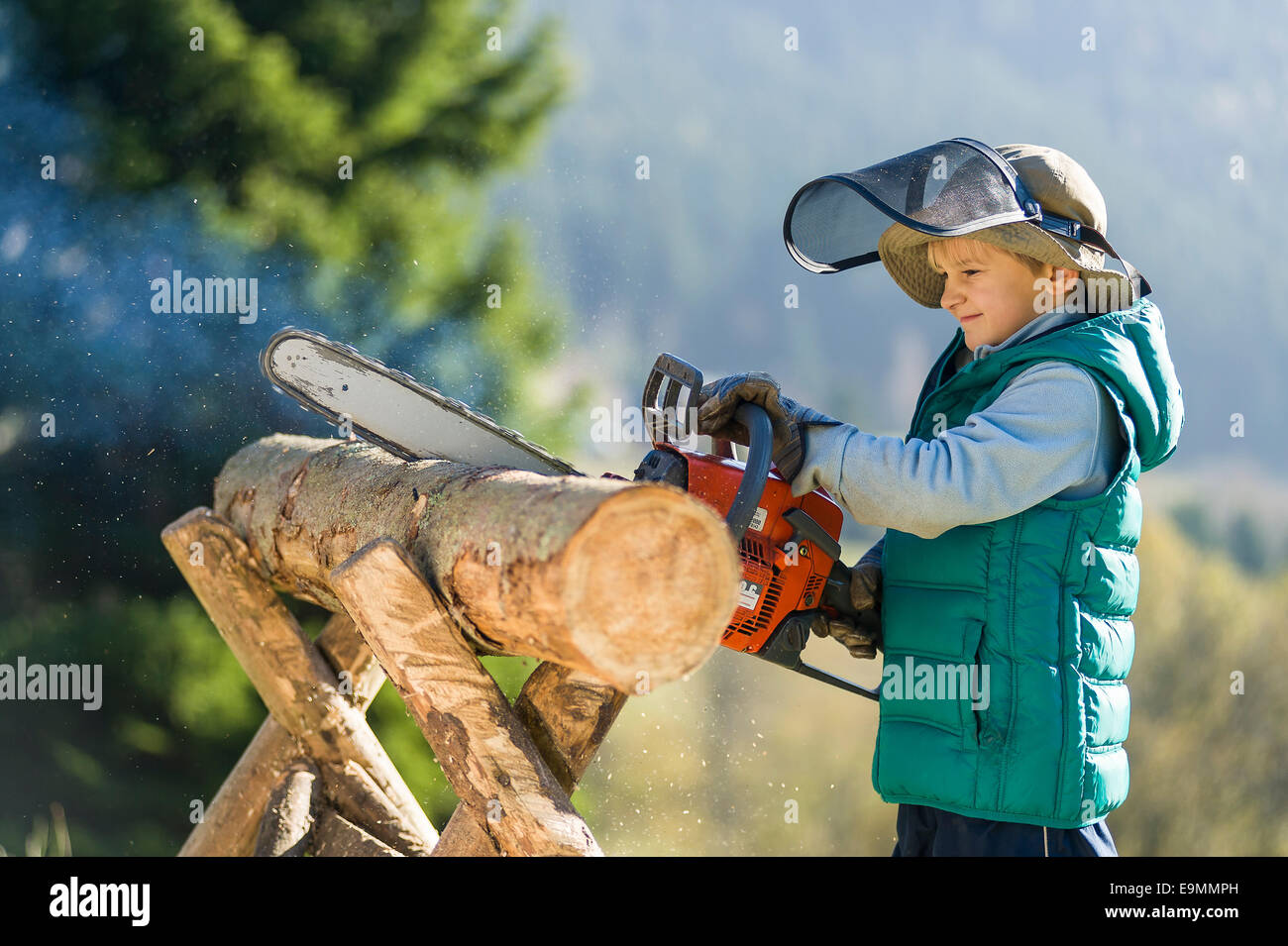 boy of eight with chainsaw cutting log Stock Photo - Alamy