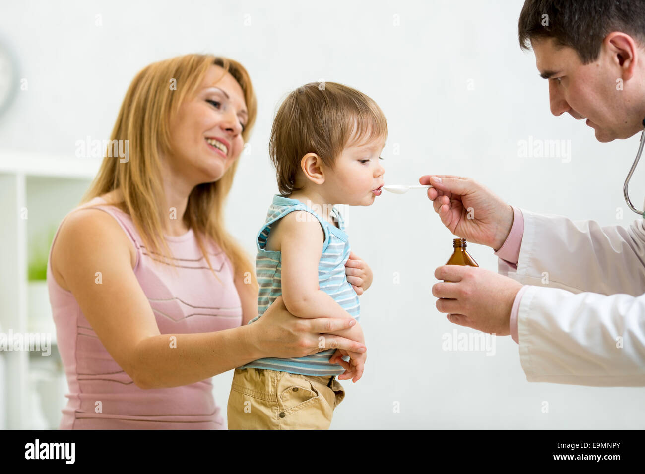 Doctor giving spoon dose of medicine drinking syrup to child Stock ...