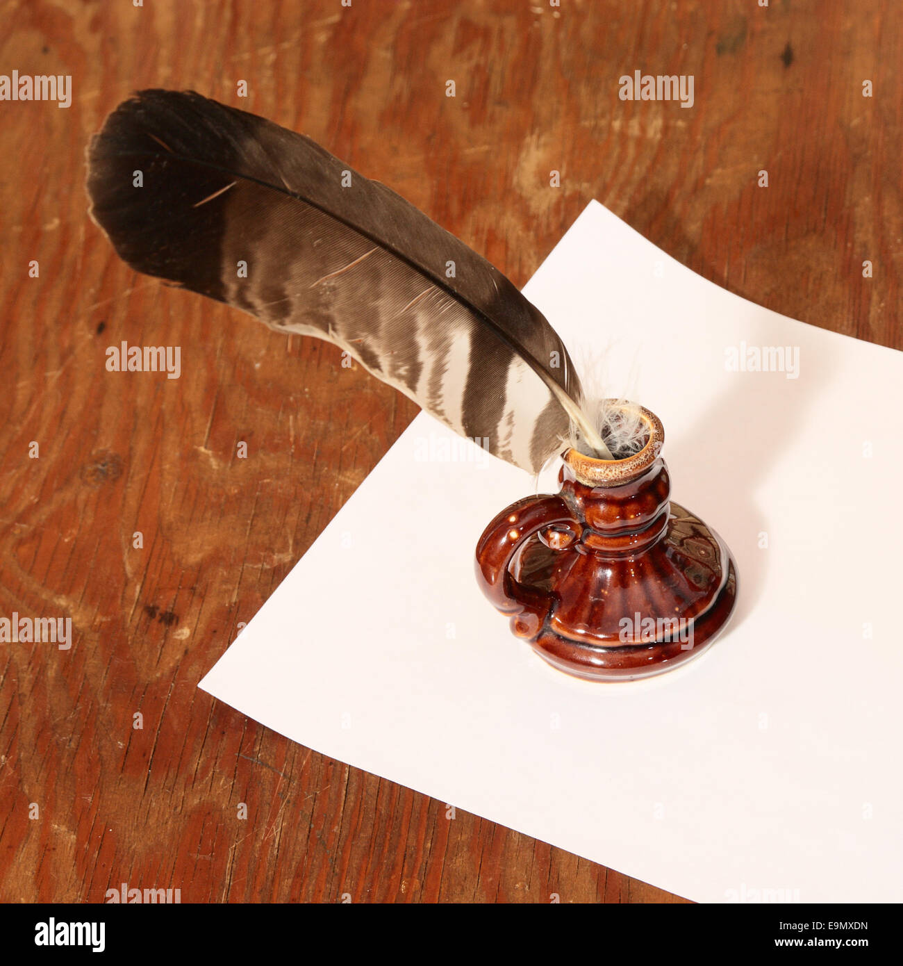 White sheet of paper and quill with inkpot on a wood background Stock ...