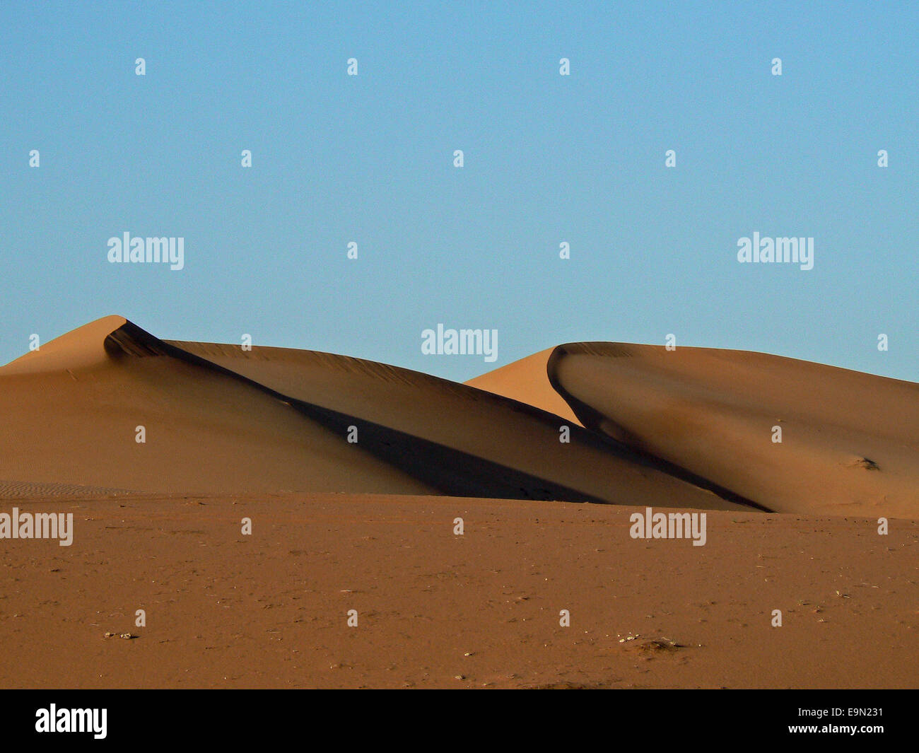 Deep red sand dunes in the Arabian desert against a blue sky Stock ...