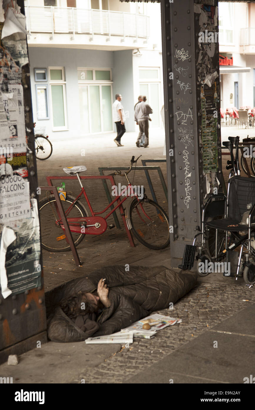 Disabled homeless man rests under a train bridge with his wheelchair ...