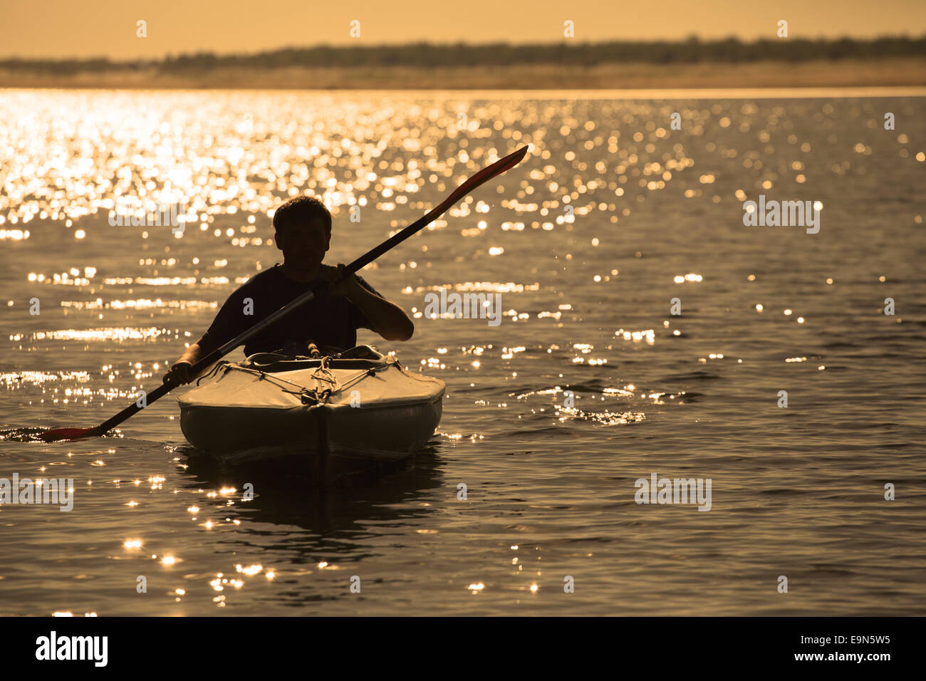 Silhouette of a man rowing in the canoe Stock Photo - Alamy