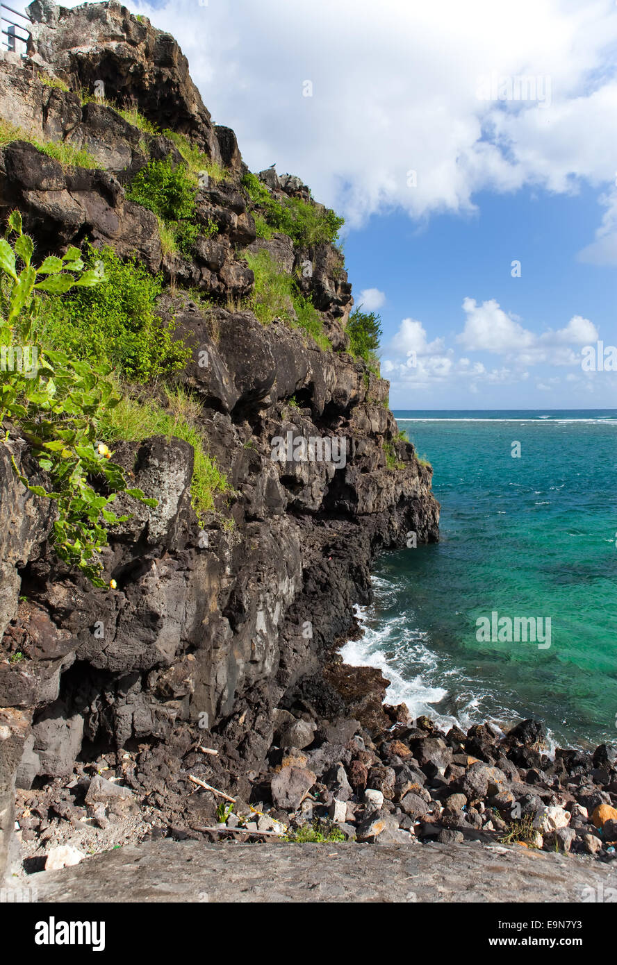 Black stones in the sea. Mauritius Stock Photo - Alamy