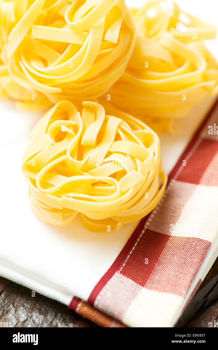 Nests of dry pasta tagliatelle vertical Stock Photo - Alamy