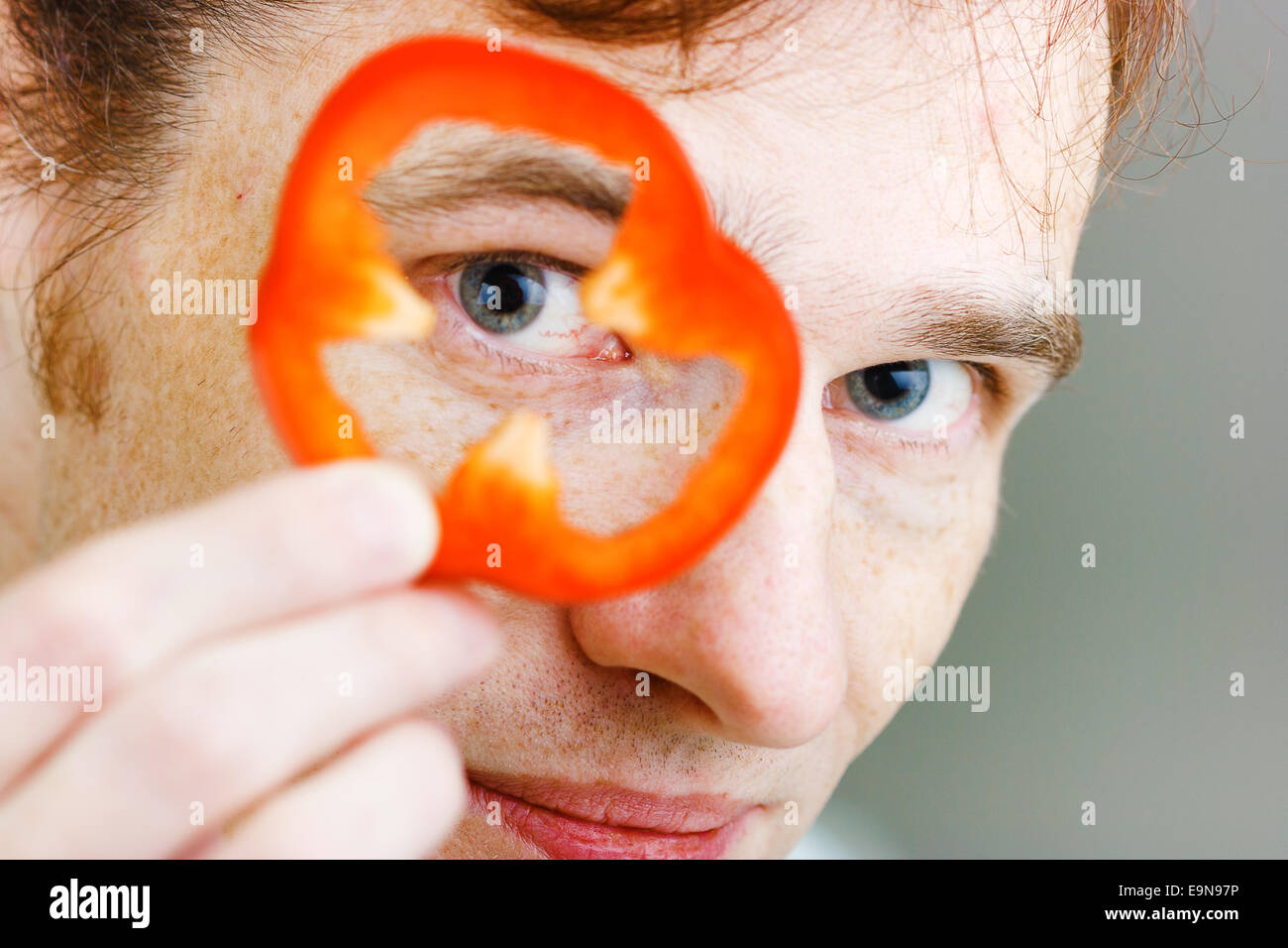 Young man with red pepper. humor Stock Photo - Alamy