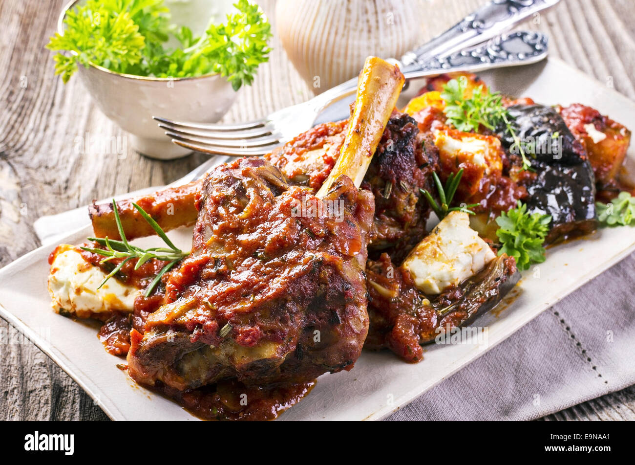 braised lamb knuckles with eggplant and feta Stock Photo - Alamy