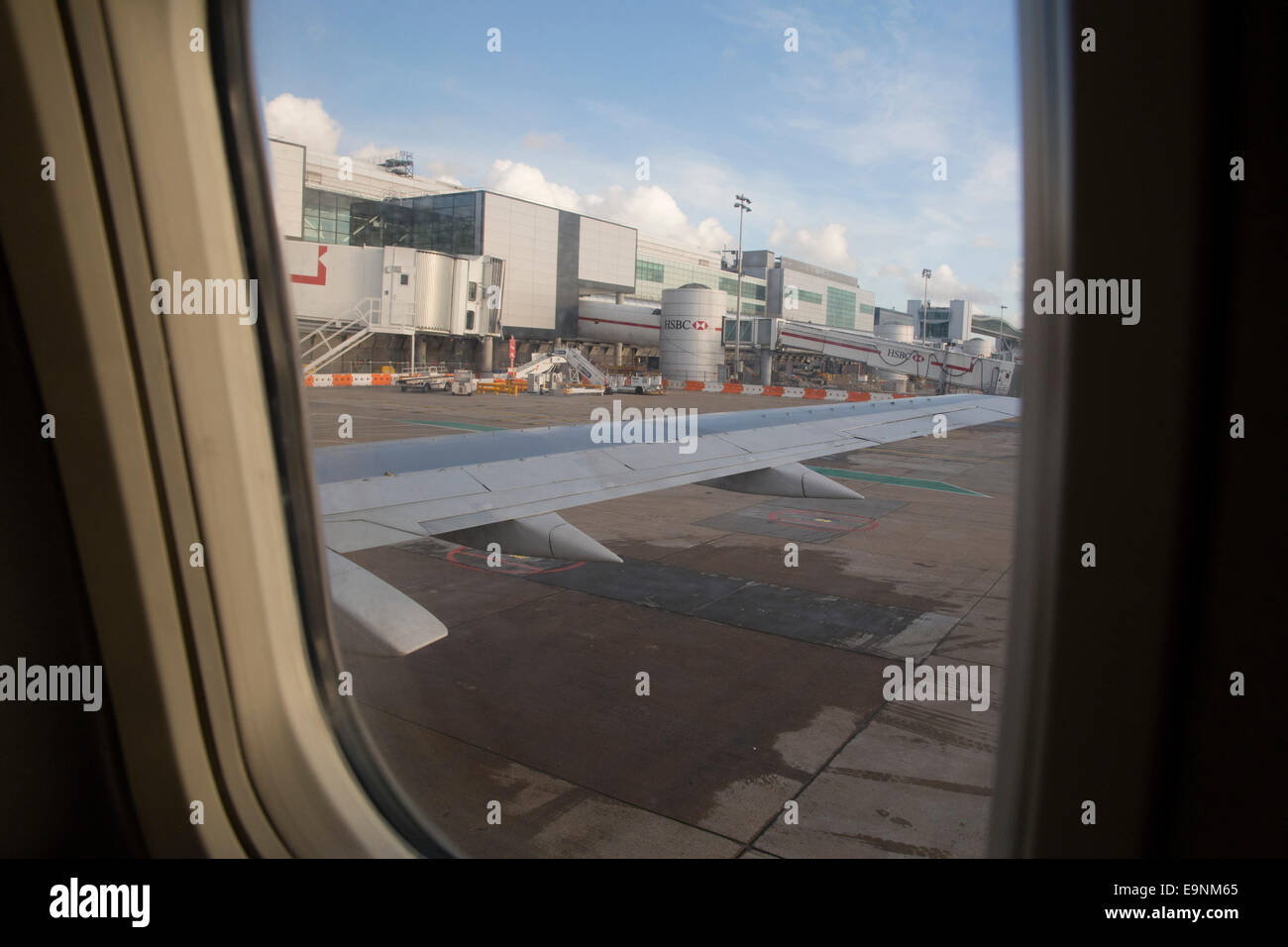 View from an aeroplane window of the plane's wing, airport buildings ...