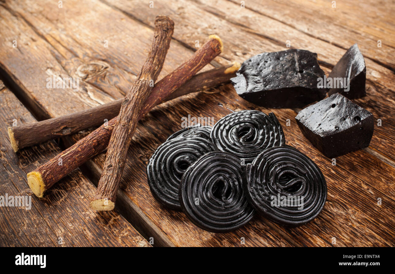 Production steps of licorice, roots, pure blocks and candy on wooden ...
