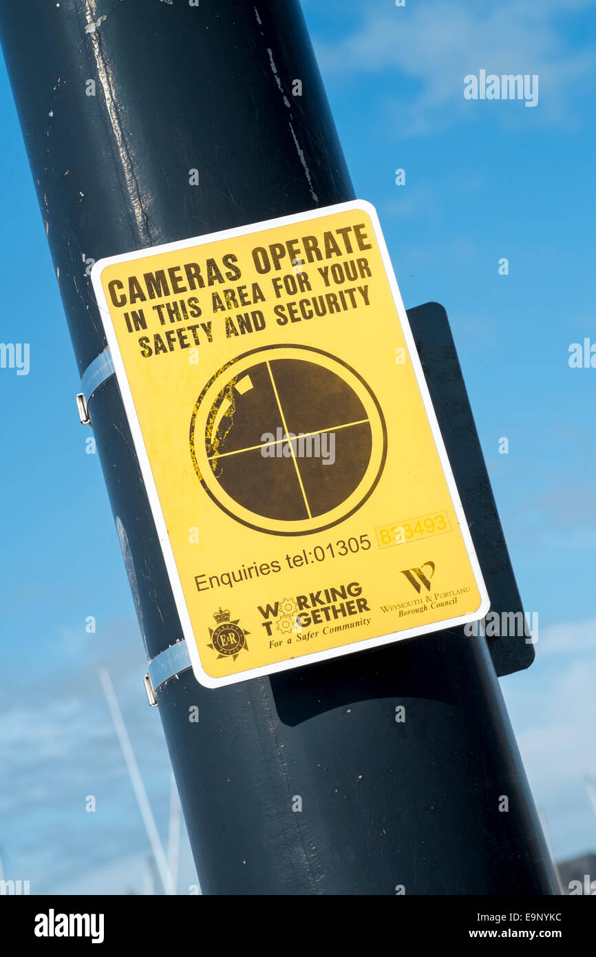 Security CCTV camera sign attached to black metal post Stock Photo - Alamy