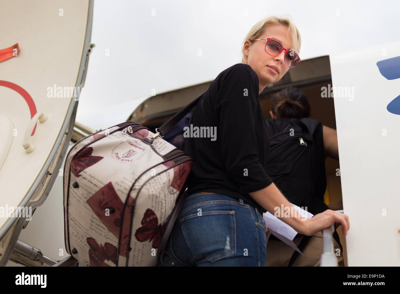 Woman boarding airplane Stock Photo - Alamy