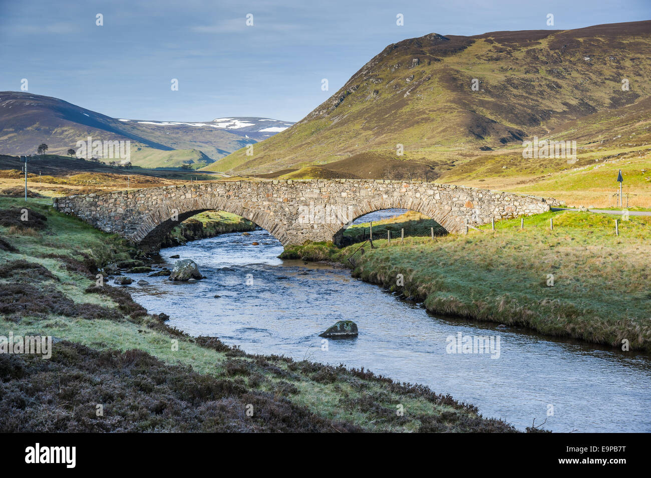 View of stone bridge over river in glen, in evening sunlight, Clunie ...
