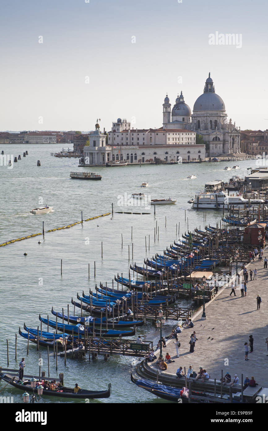 View of gondolas moored along waterfront with Roman Catholic church in ...
