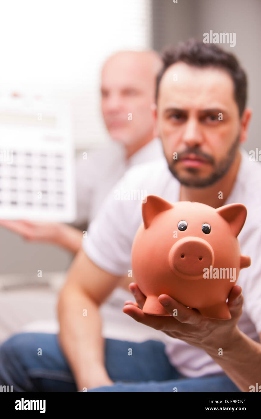 a couple of men with economic problems showing up a piggybank and a ...