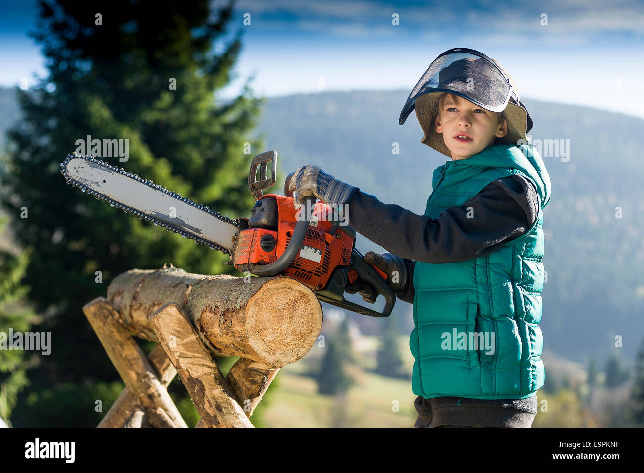 boy of ten with chainsaw cutting log Stock Photo - Alamy