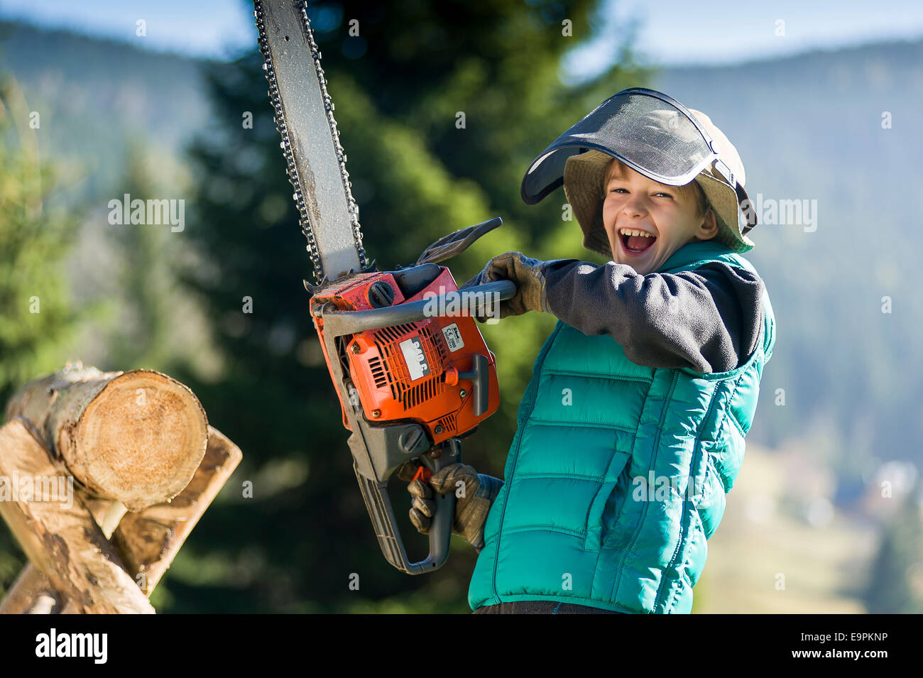 boy of ten with chainsaw cutting log Stock Photo - Alamy