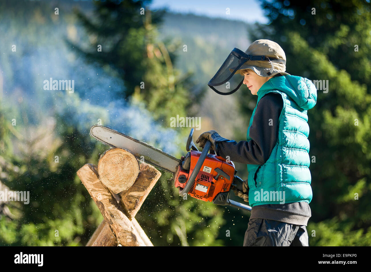 boy of ten with chainsaw cutting log Stock Photo - Alamy
